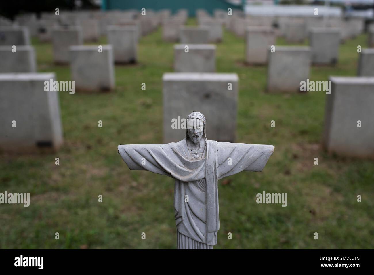 A miniature Christ the Redeemer statue adorns a tombstone at the ...