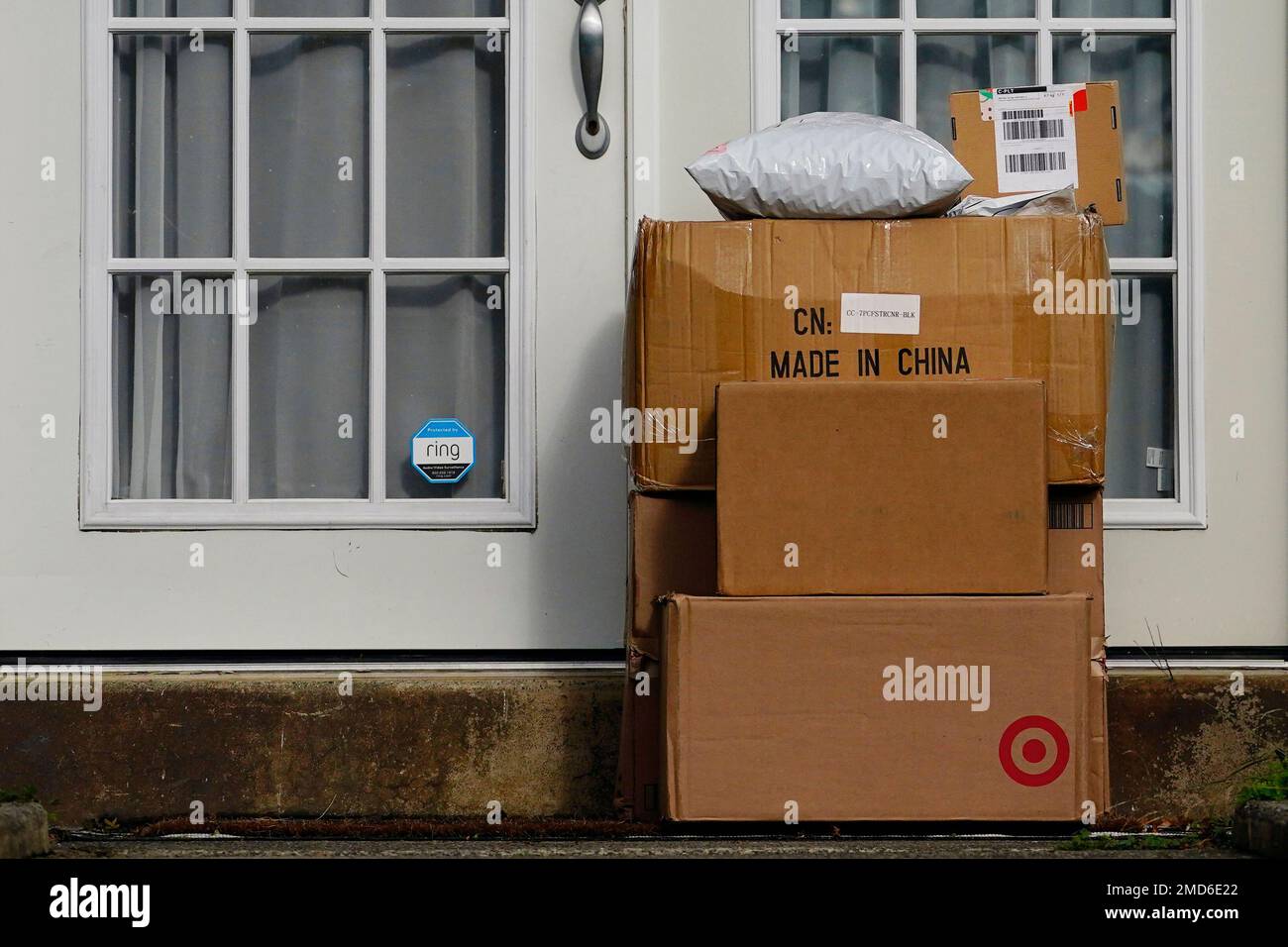 Packages are seen stacked on the doorstep of a residence, Wednesday ...
