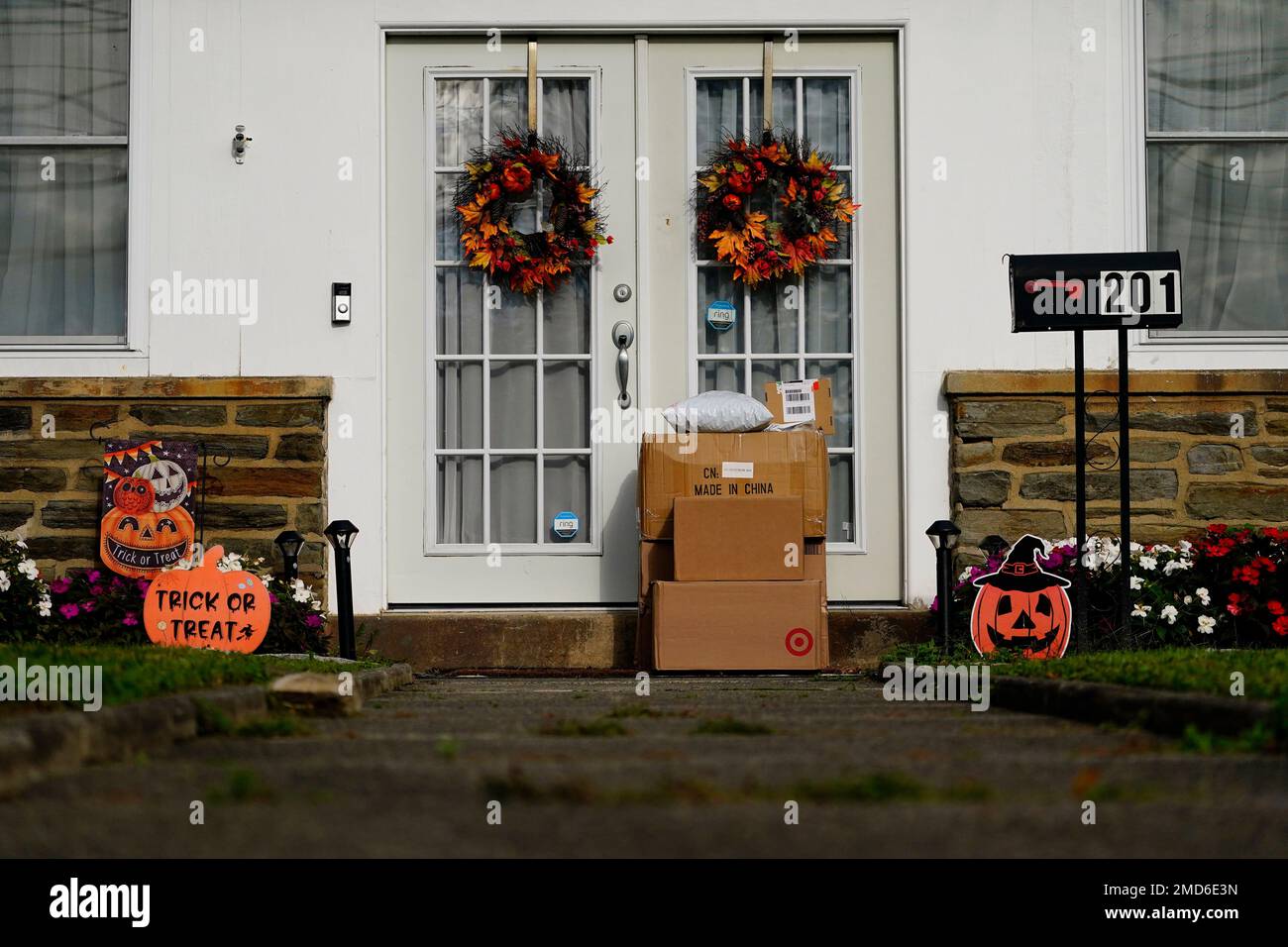 Packages are seen stacked on the doorstep of a residence, Wednesday ...