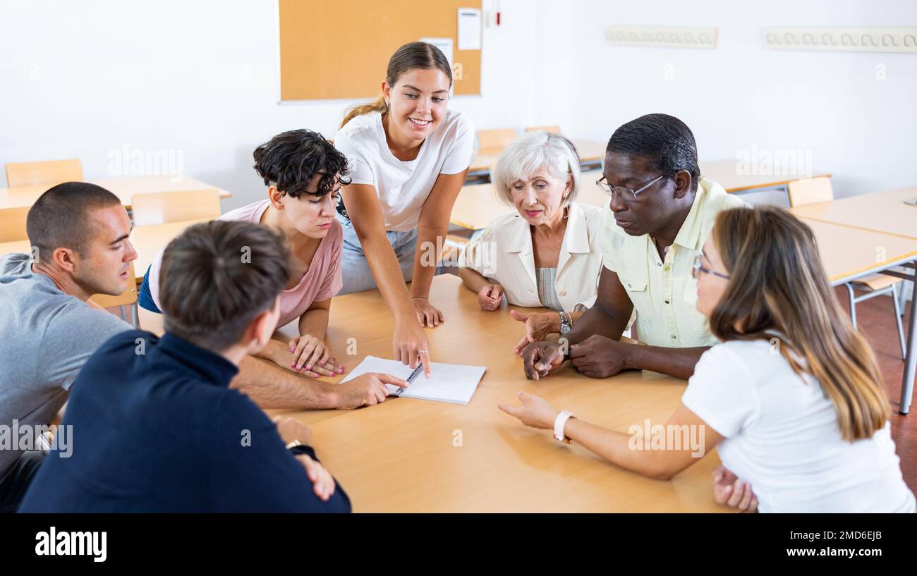 Young girl participating in Spanish language speaking club with group ...