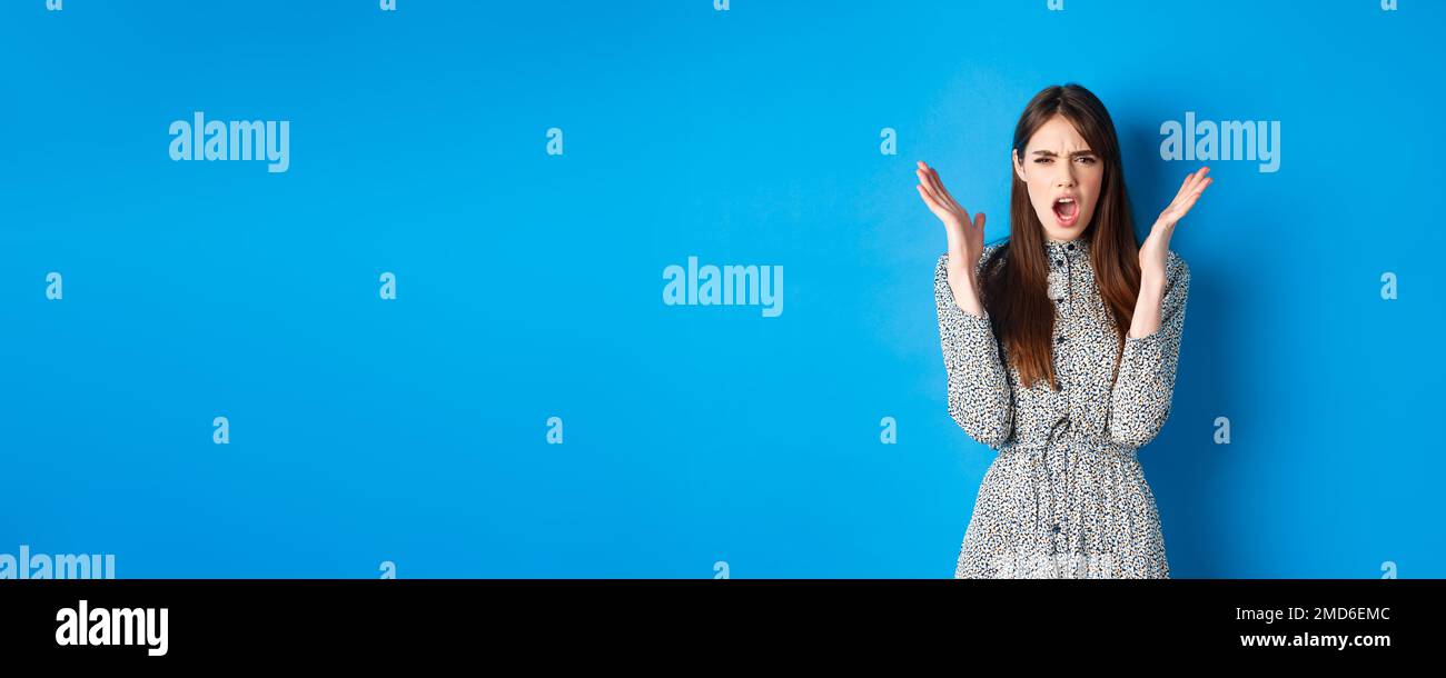 Frustrated and angry woman in dress, scream and frown at camera ...