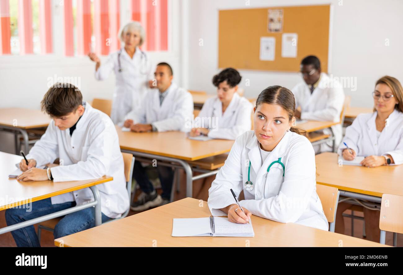 Young girl medical student taking notes during group lecture Stock ...