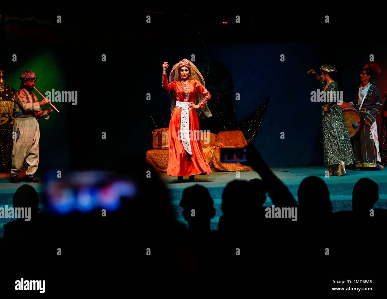Performers dressed in traditional Iraqi folk costumes dance in the ...