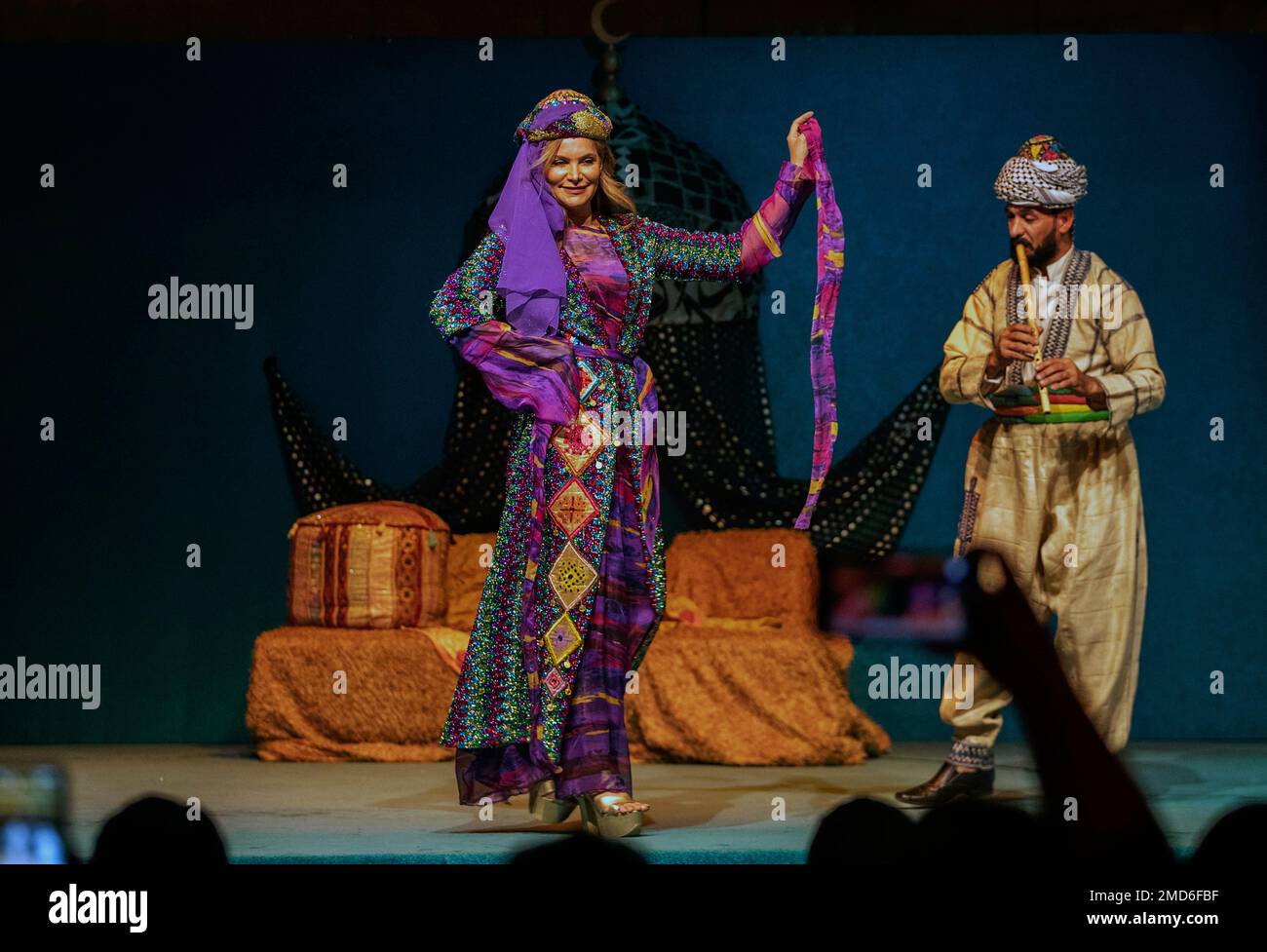 Performers dressed in traditional Iraqi folk costumes dance in the ...
