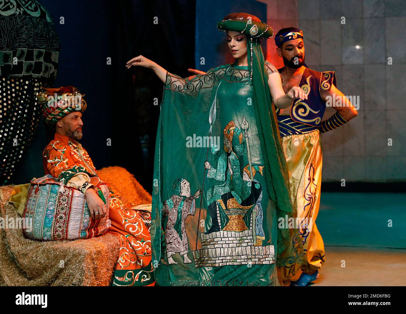 Performers dressed in traditional Iraqi folk costumes dance in the ...