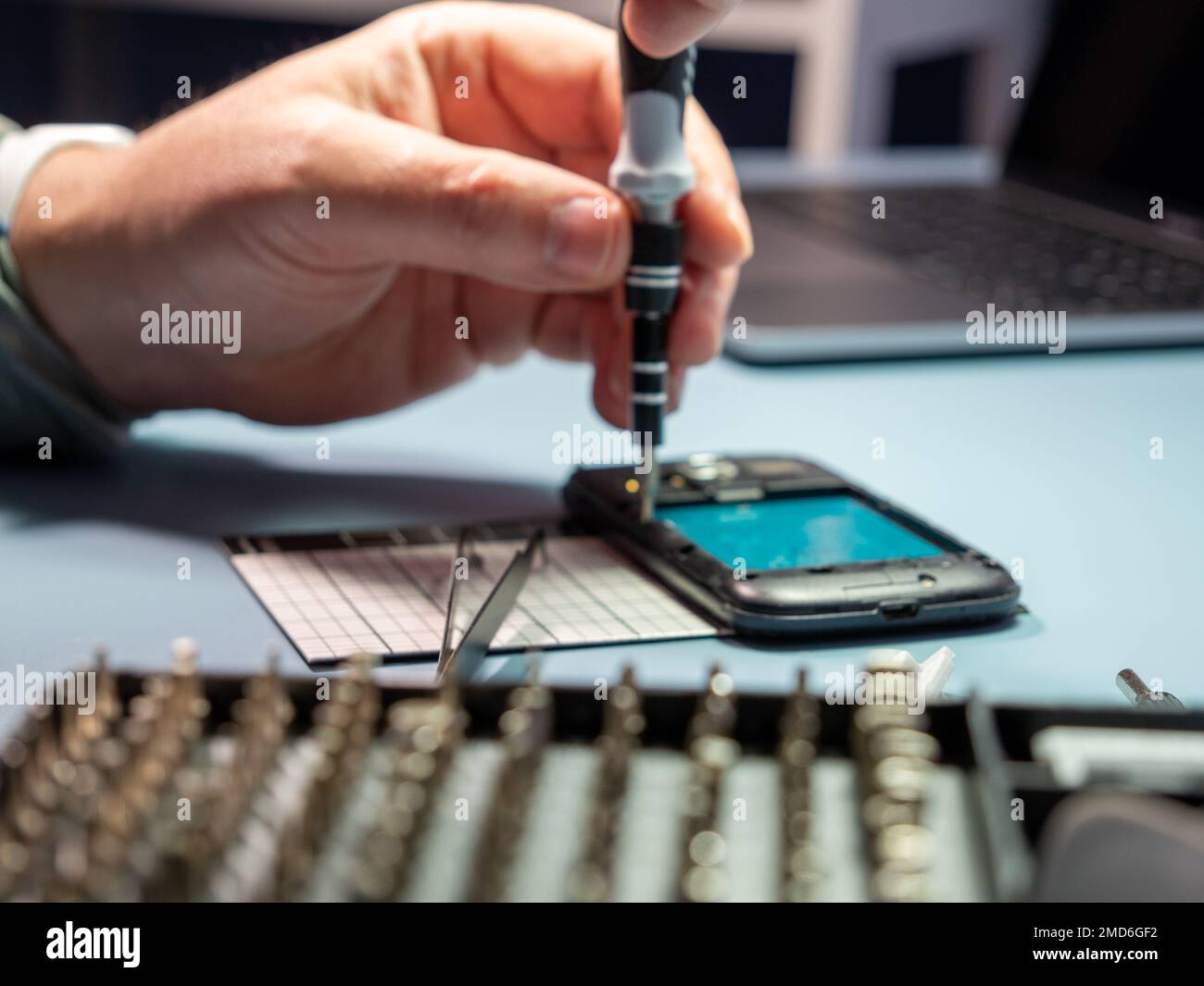 A technician repairs a smartphone in a laboratory with copy space ...