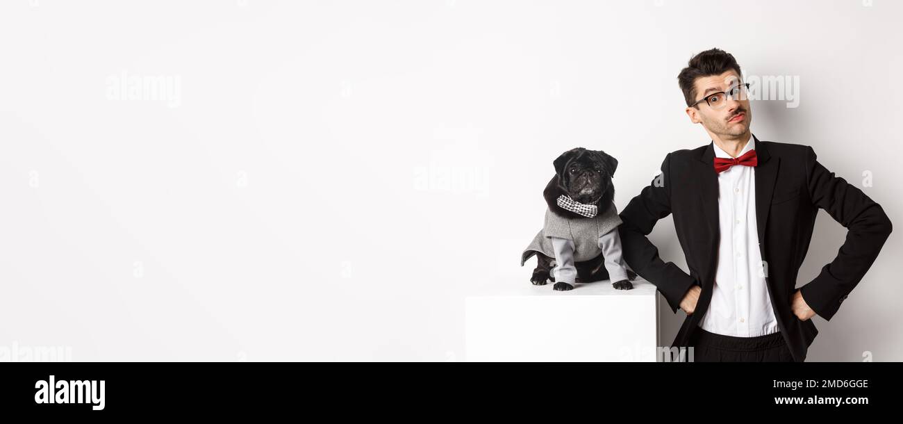 Animals, party and celebration concept. Handsome young man and puppy in ...