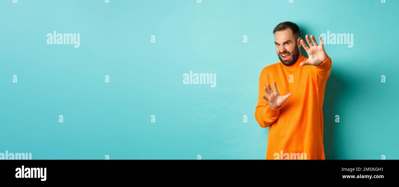 Disgusted man cringe and extending hands in protection, begging for ...