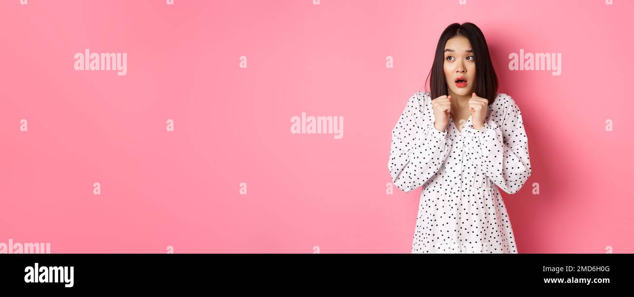 Scared and timid asian girl trembling from fear, staring left and ...