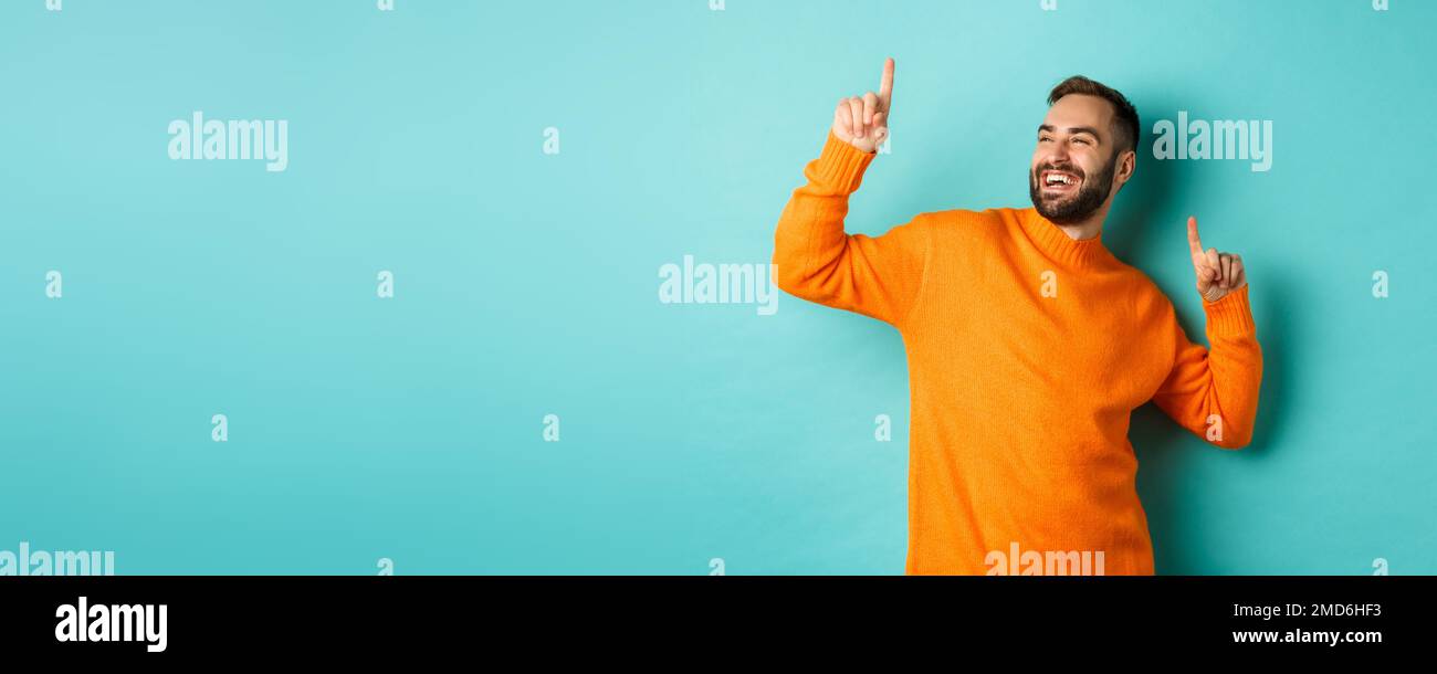 Handsome man celebrating, feeling winner, pointing fingers up and do ...