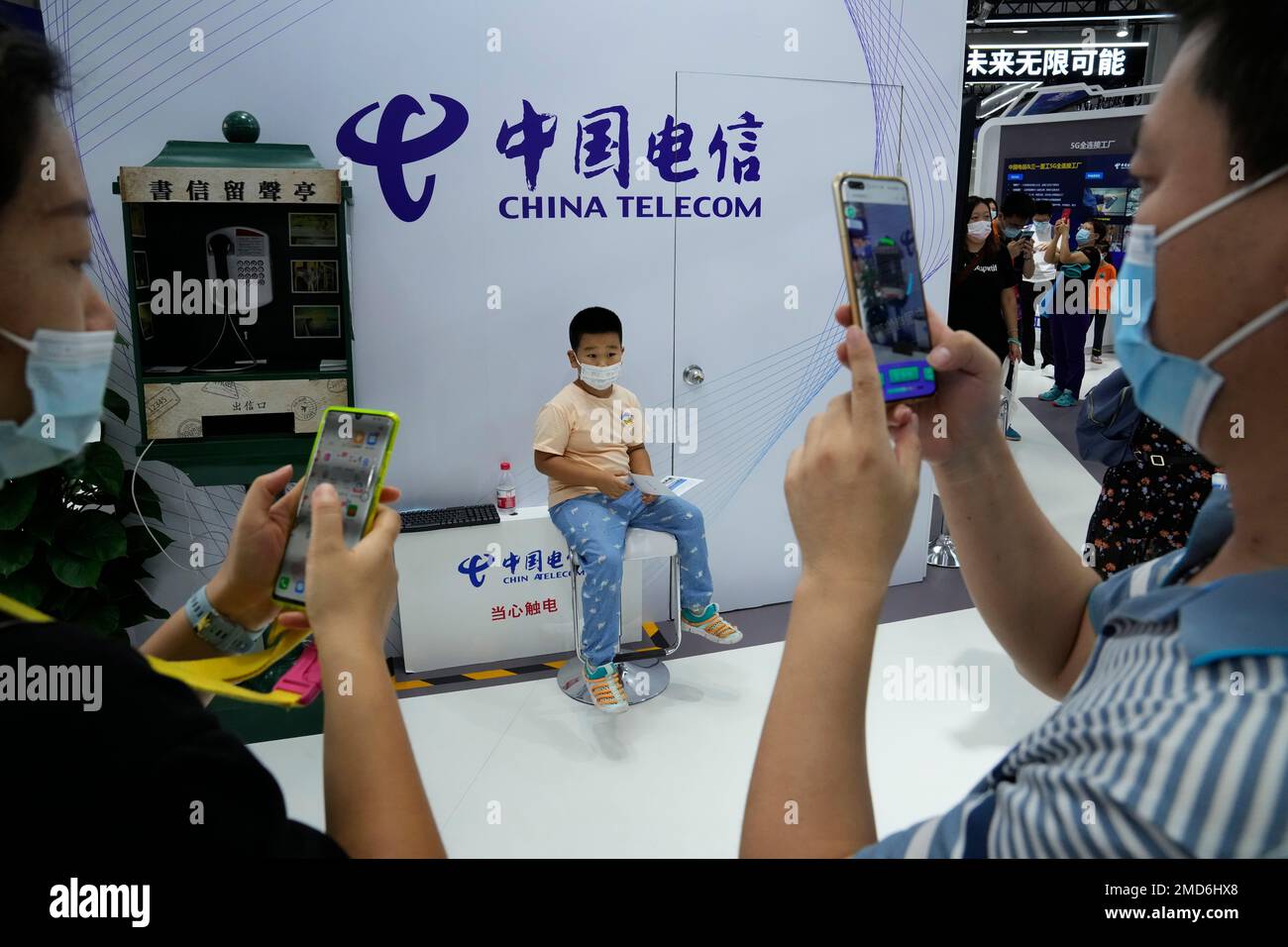 Visitors take photos near an antique telephone booth and a child at the ...