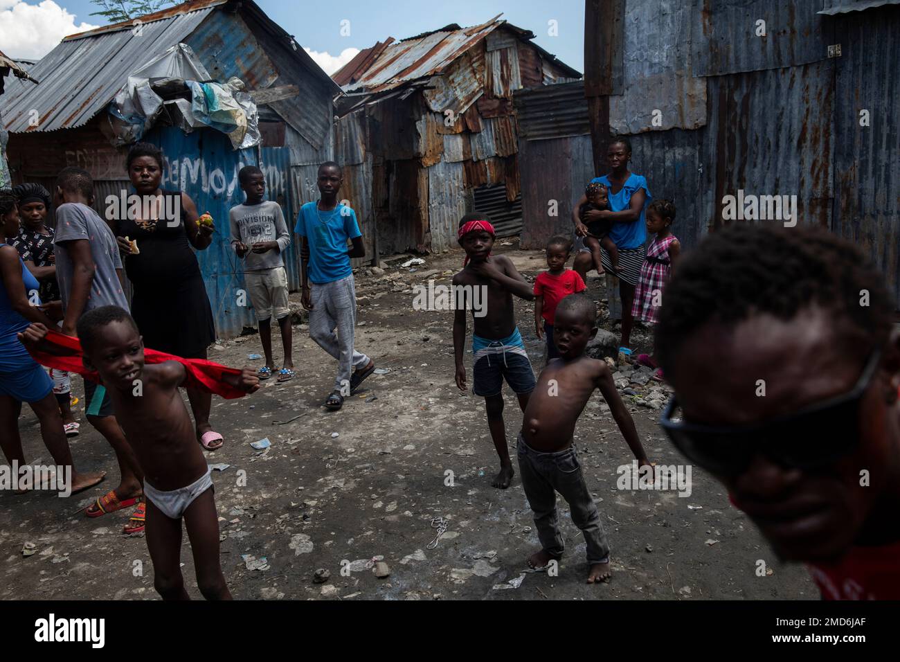 Neighbors gather outside their homes built with recycled metal sheets ...
