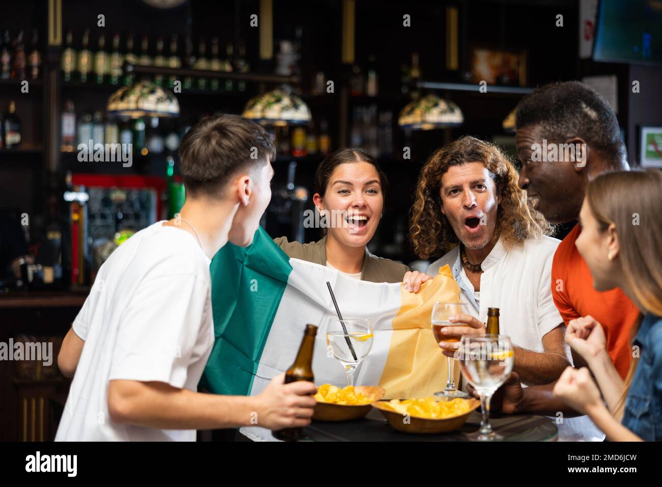 Group of excited sports fans celebrating victory of favorite Irish team ...