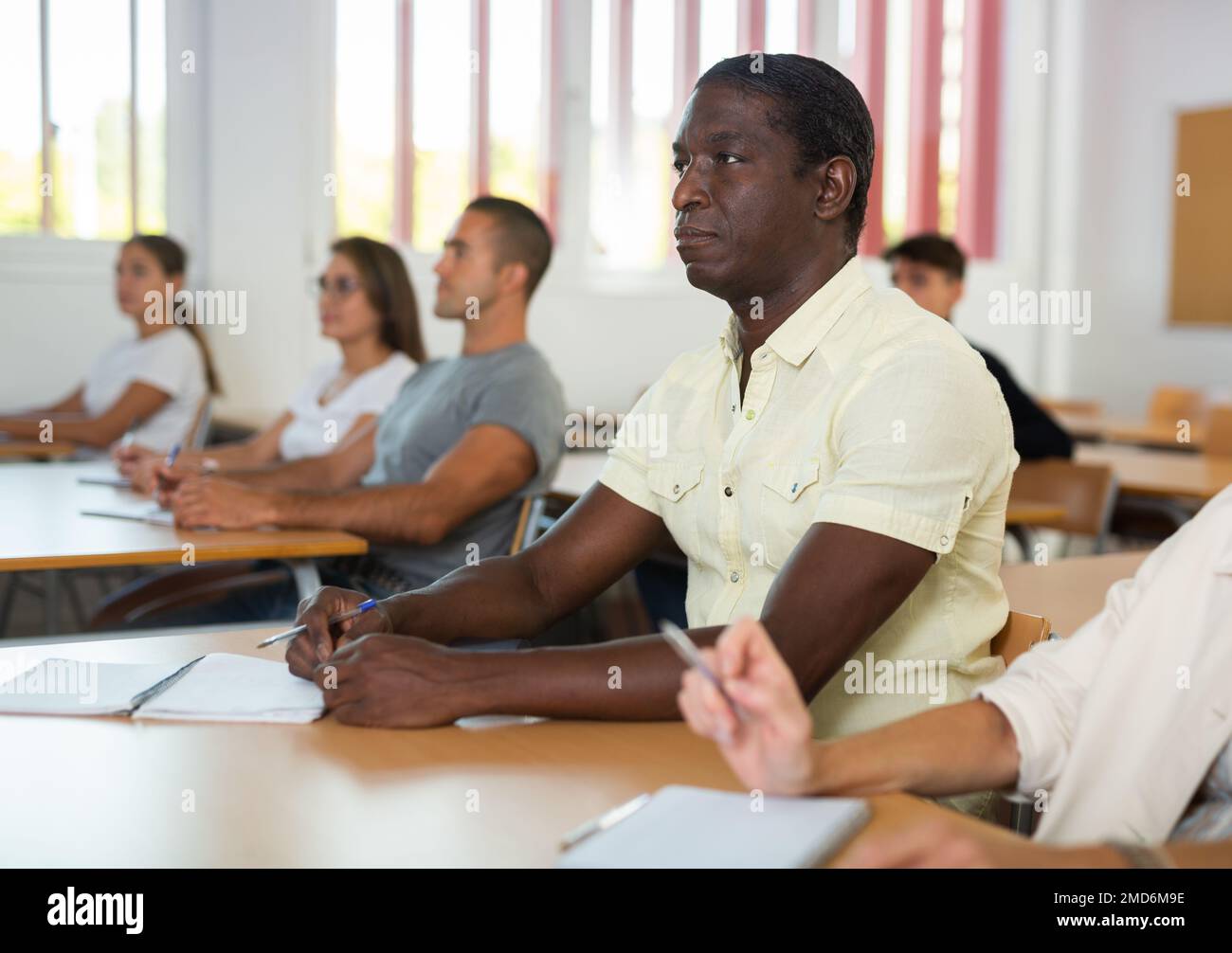 Portrait of adult african american student who writing exercises at ...