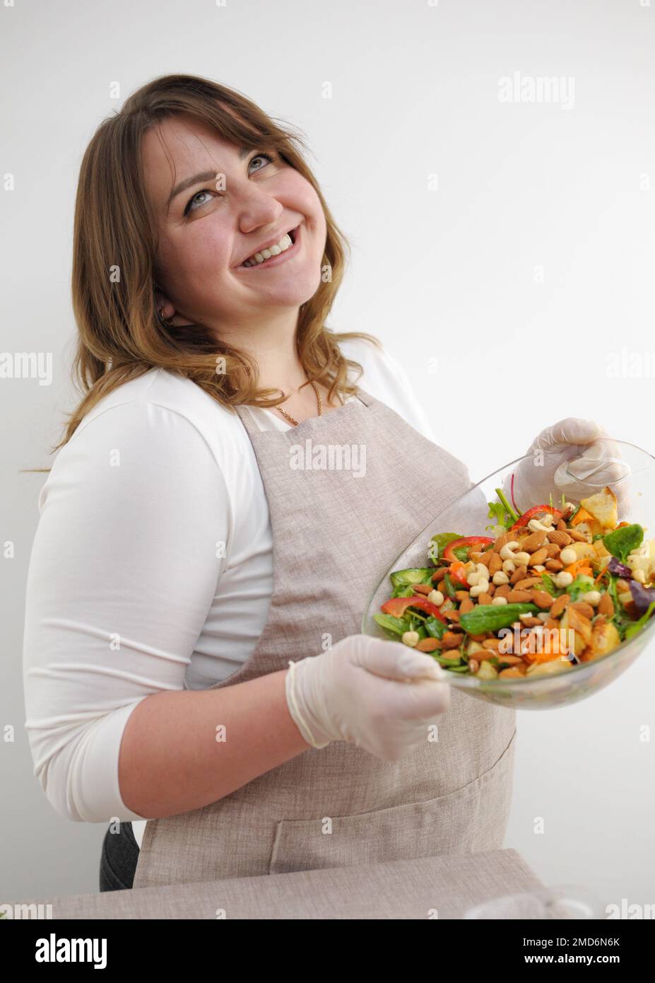 successful promotional photo of beautiful curvy woman preparing salad ...