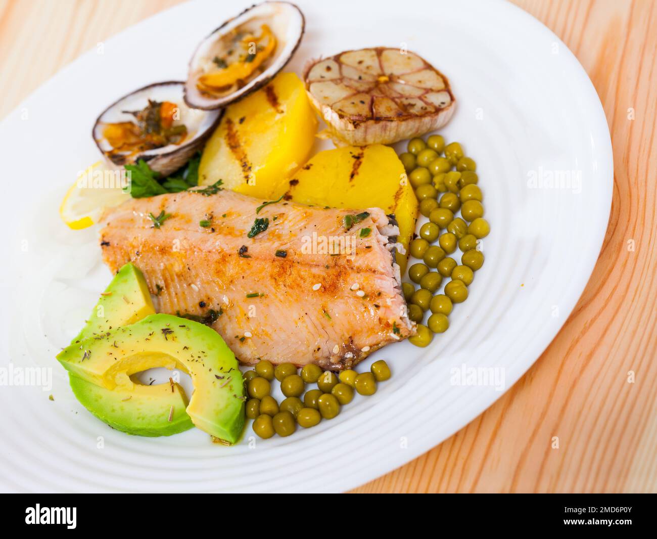 Fried trout fillets served with vegetables, seashells and avocado at ...