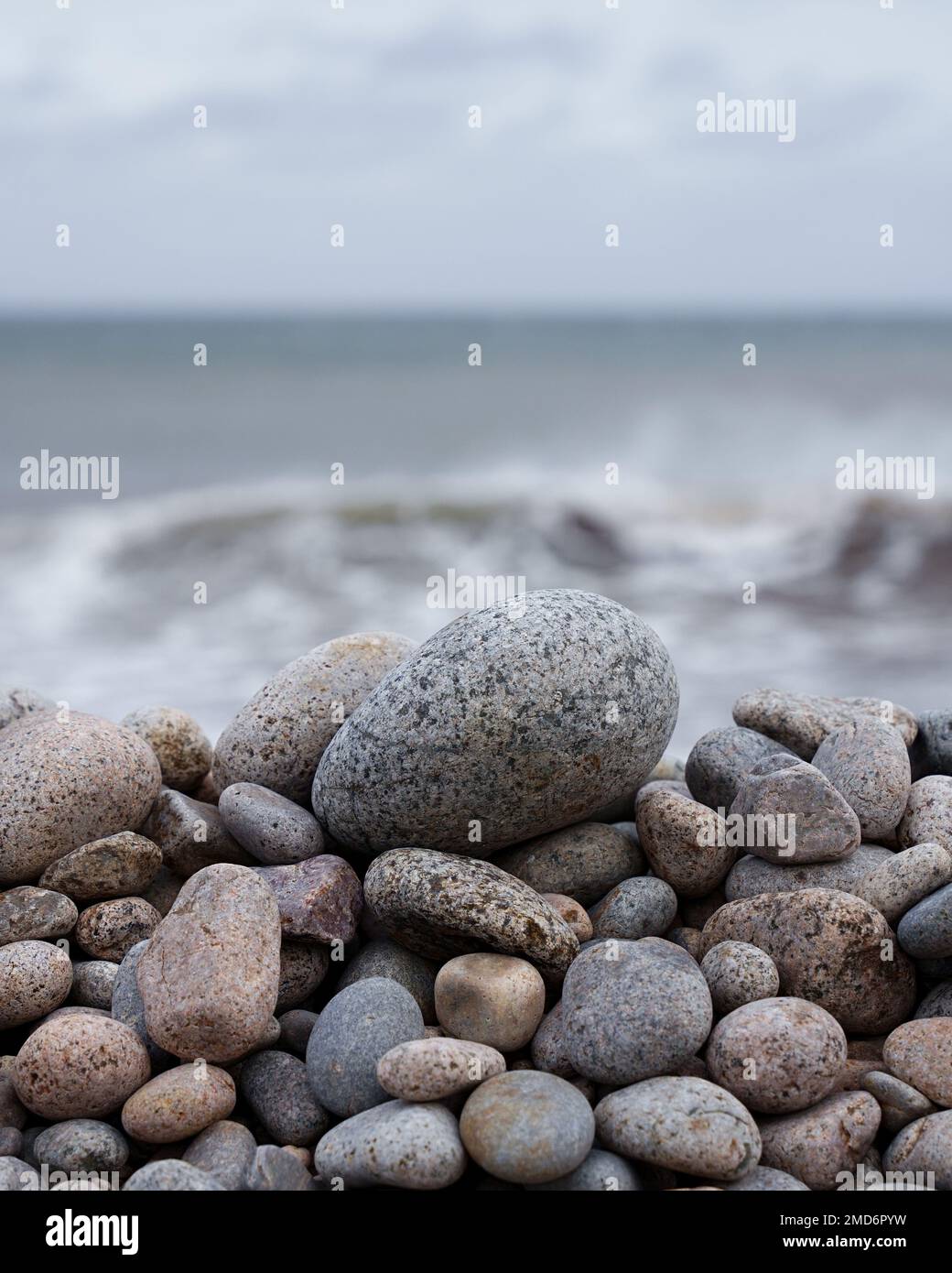 A vertical shot of pebbles on the sea coast Stock Photo - Alamy