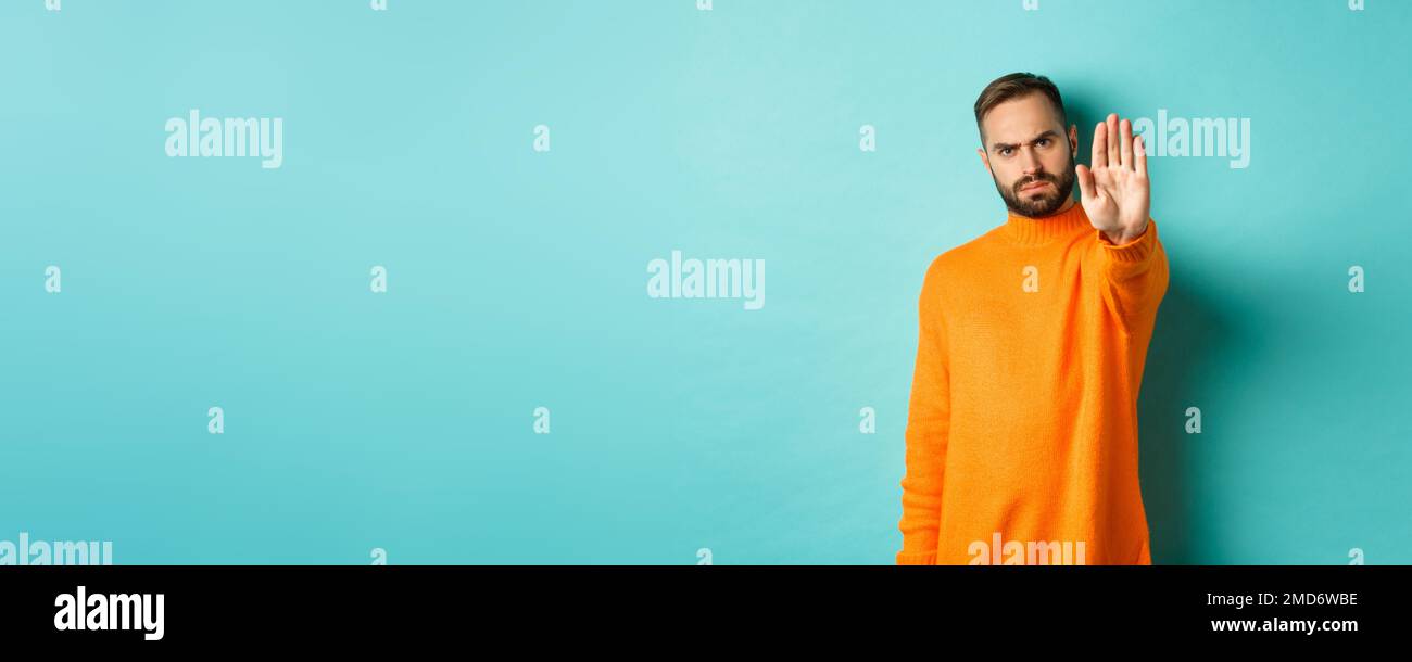 Serious frowning man showing stop gesture, telling no, prohibit and ...