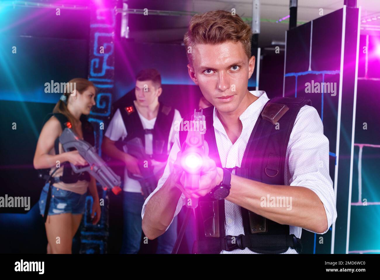 Portrait of excited guy with laser pistol playing laser tag in a Stock ...
