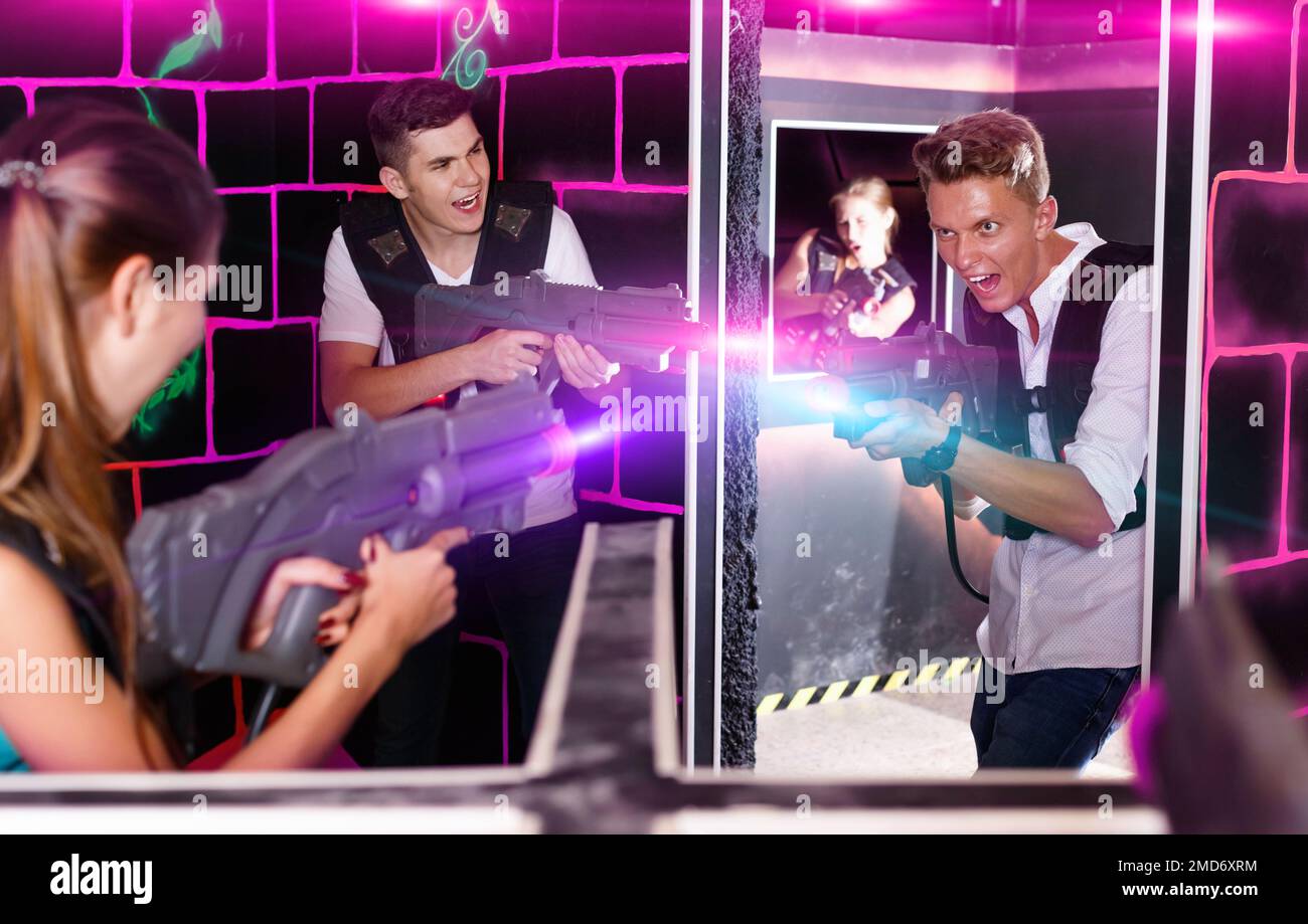 Laser tag players guys and girls playing in teams in dark laser Stock ...