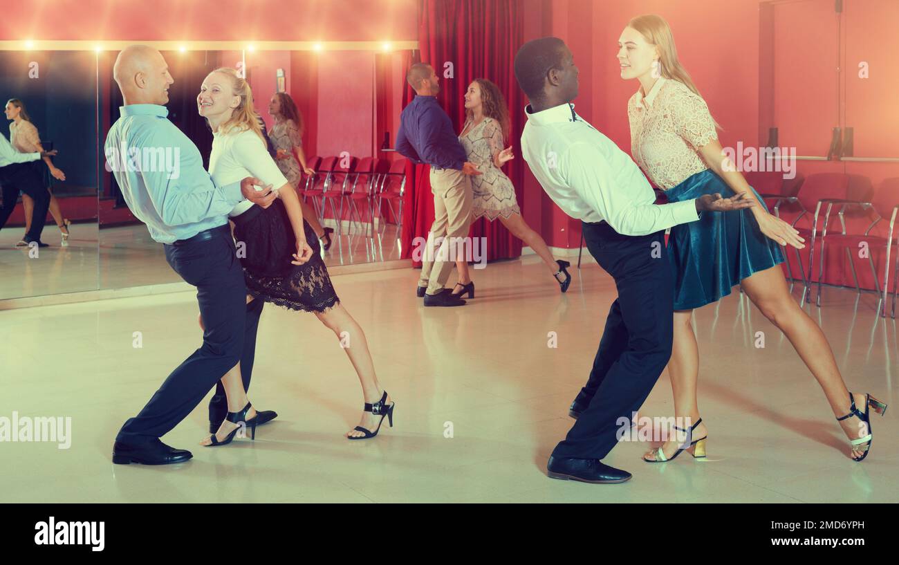 Adult pairs dancing tango movements in modern dance studio Stock Photo ...