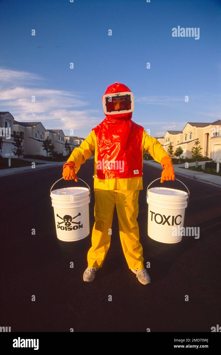 Person dressed in a colorful hazmat suit holding two buckets, one ...