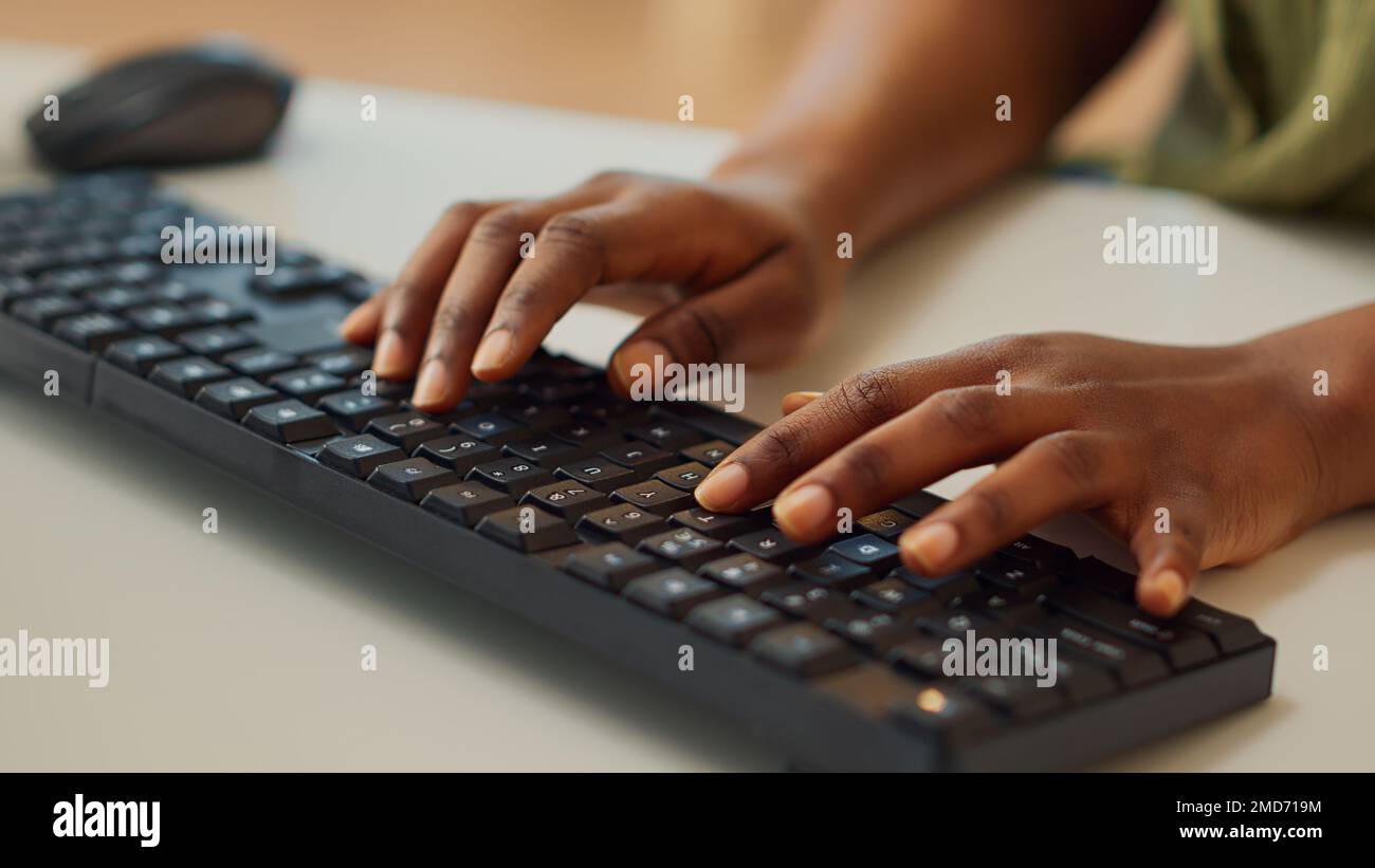 Young employee typing information on computer, using keyboard to create ...