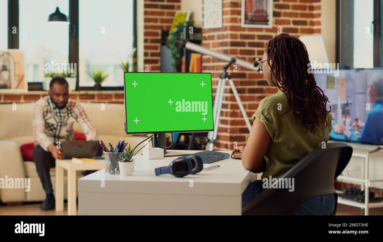 Female freelancer using computer with greenscreen, work from home with ...