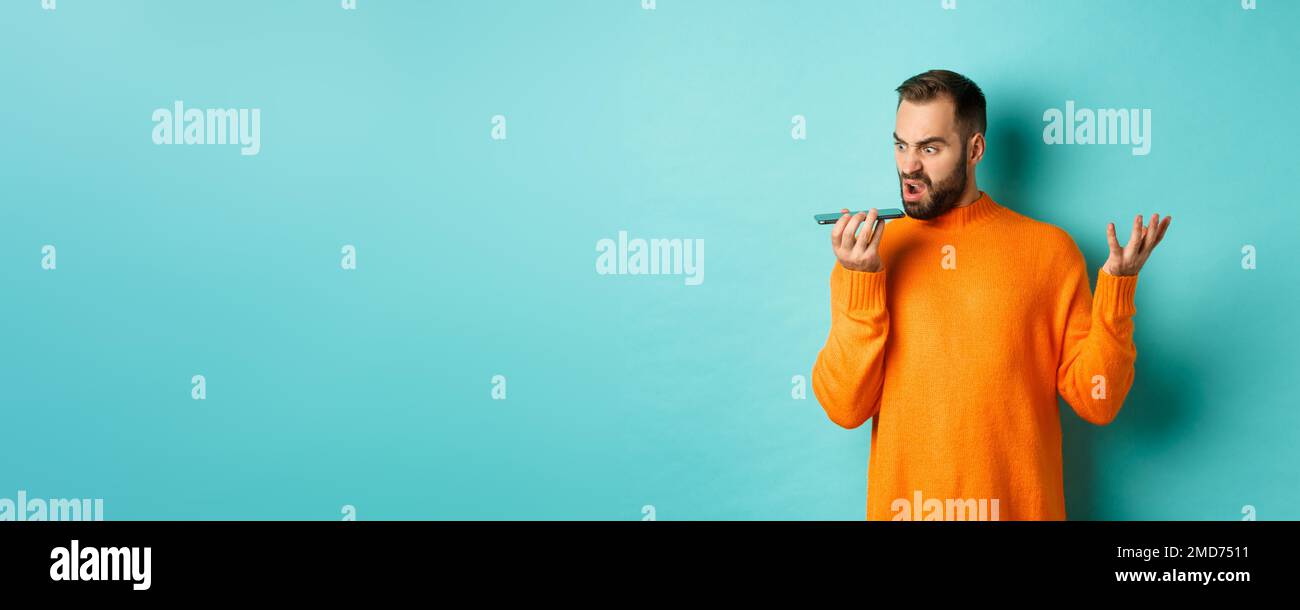 Angry man arguing on speakerphone, record voice message with mad face ...