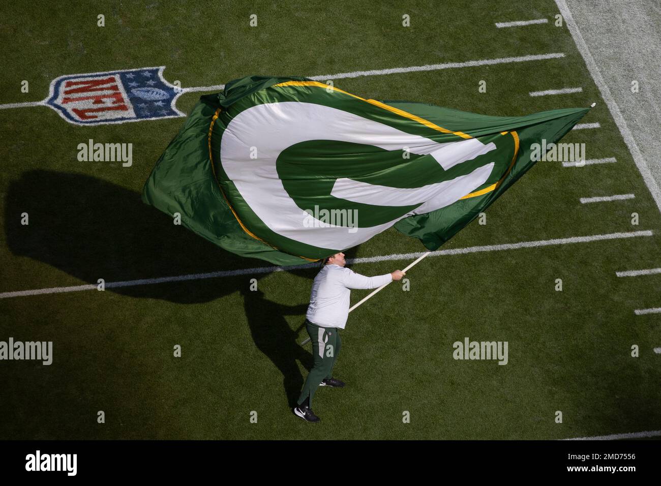 A worker waves a Green Bay Packers flag before their NFL football game ...