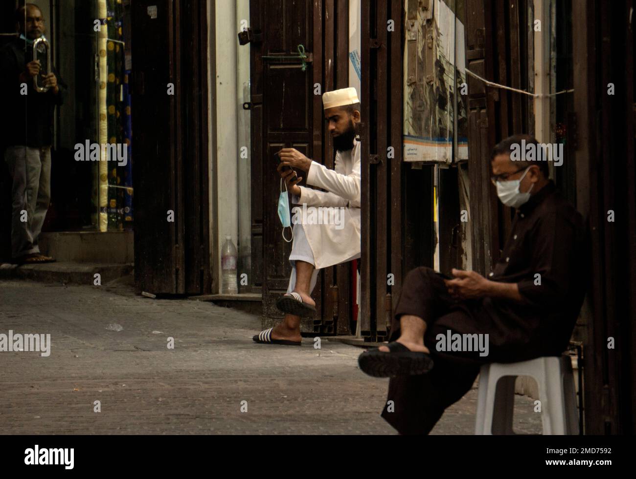 Saudi shopkeepers wait for customers outside their shops in the ...