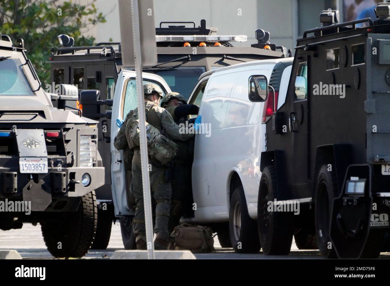 Members of a SWAT team enter a van and look through its contents in ...