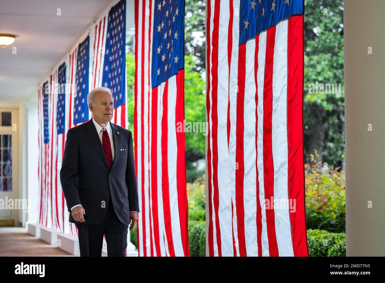 President Joe Biden walks along the West Colonnade of the White House ...