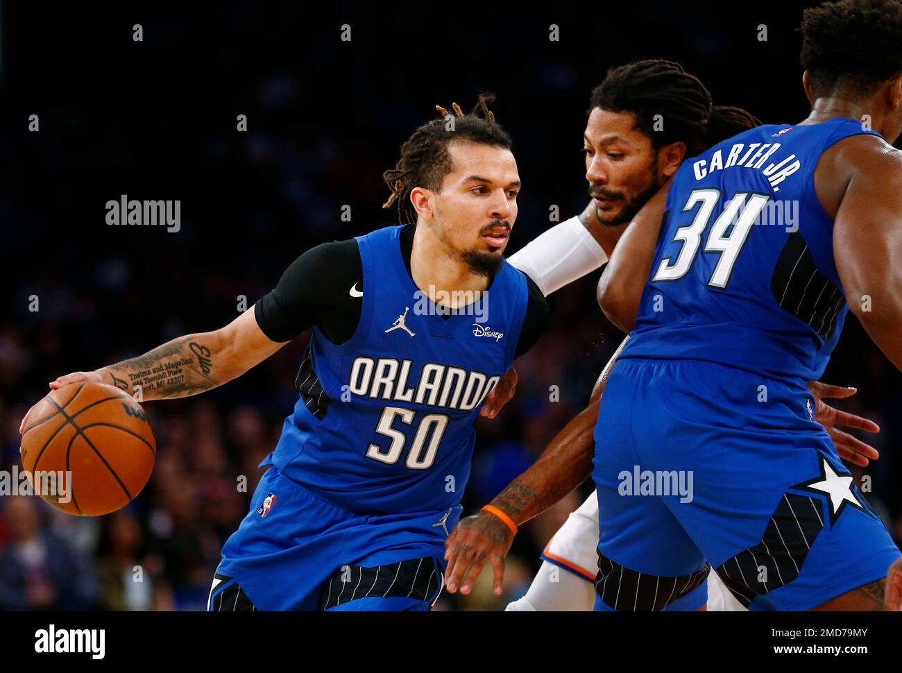 Orlando Magic's Cole Anthony (50) dribbles around teammate Wendell ...