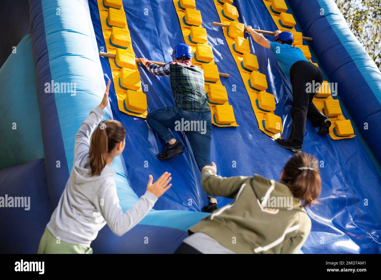 Friends climbing on inflatable slide in amusement park Stock Photo - Alamy