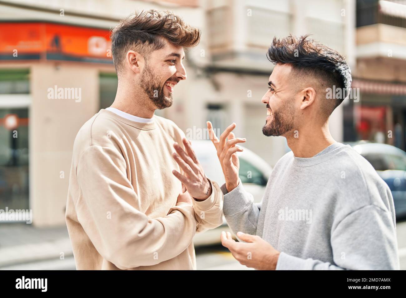 Young couple standing together speaking at street Stock Photo - Alamy