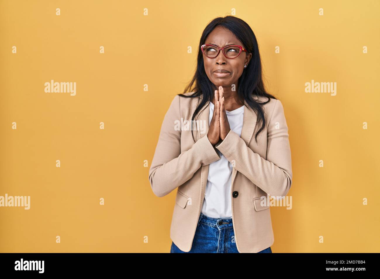 African young woman wearing glasses begging and praying with hands ...