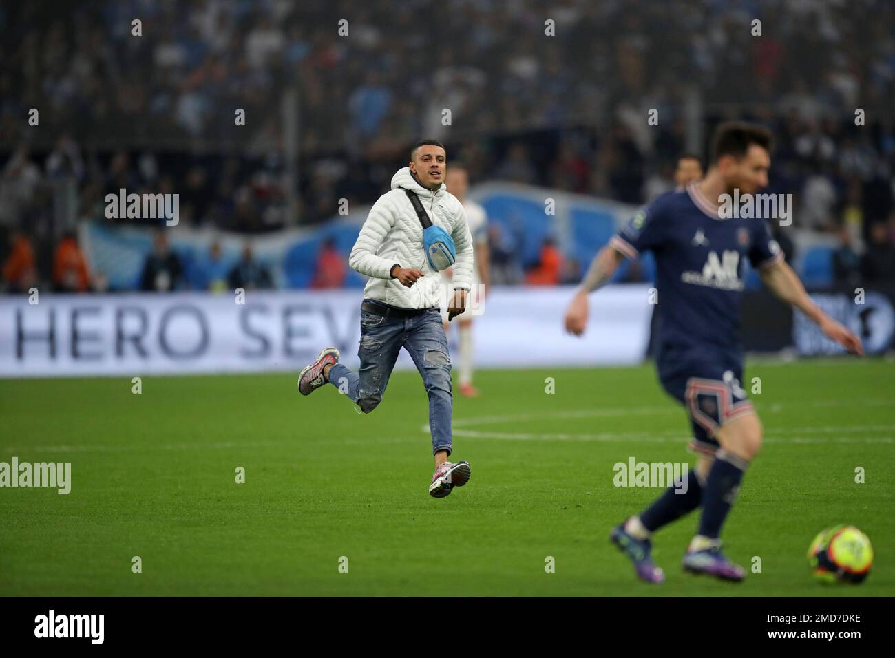 A man runs toward PSG's Lionel Messi after running onto the pitch ...