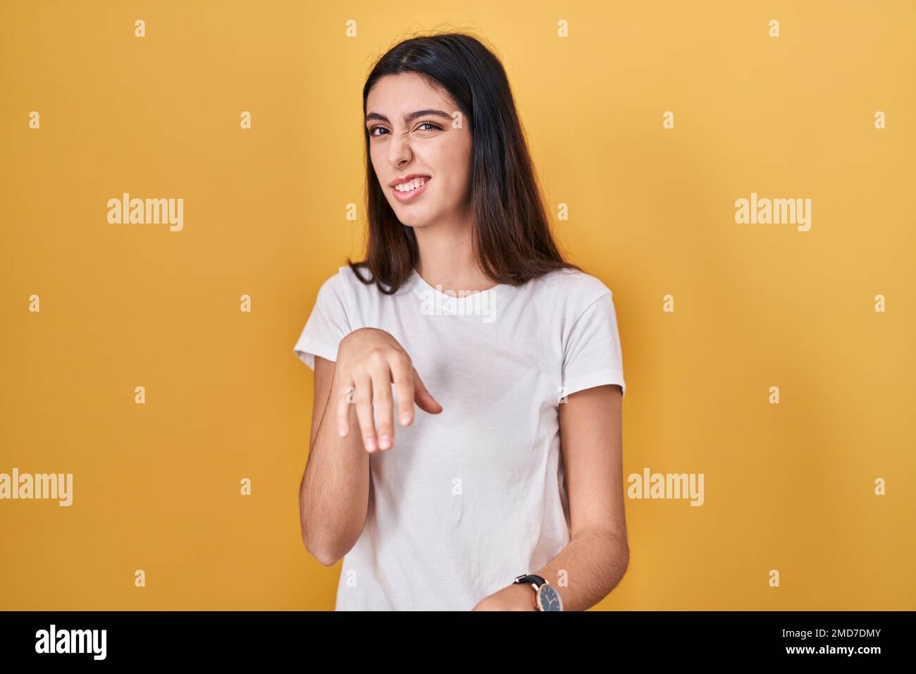 Young beautiful woman standing over yellow background disgusted ...