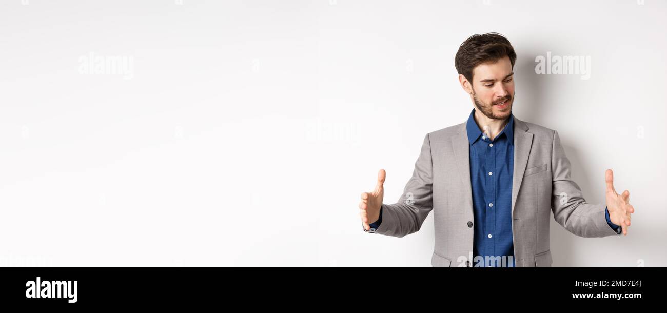 Excited handsome businessman showing long size thing, big object with ...