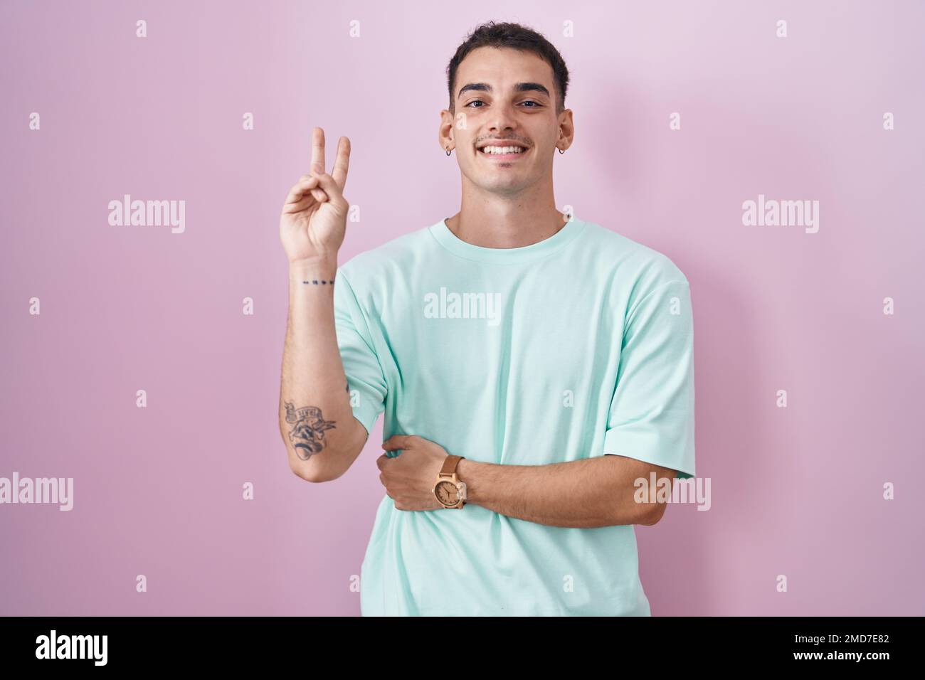 Handsome hispanic man standing over pink background smiling with happy ...
