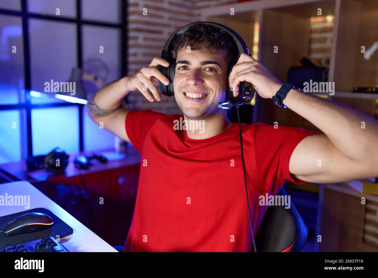 Young hispanic man streamer smiling confident sitting on table at ...