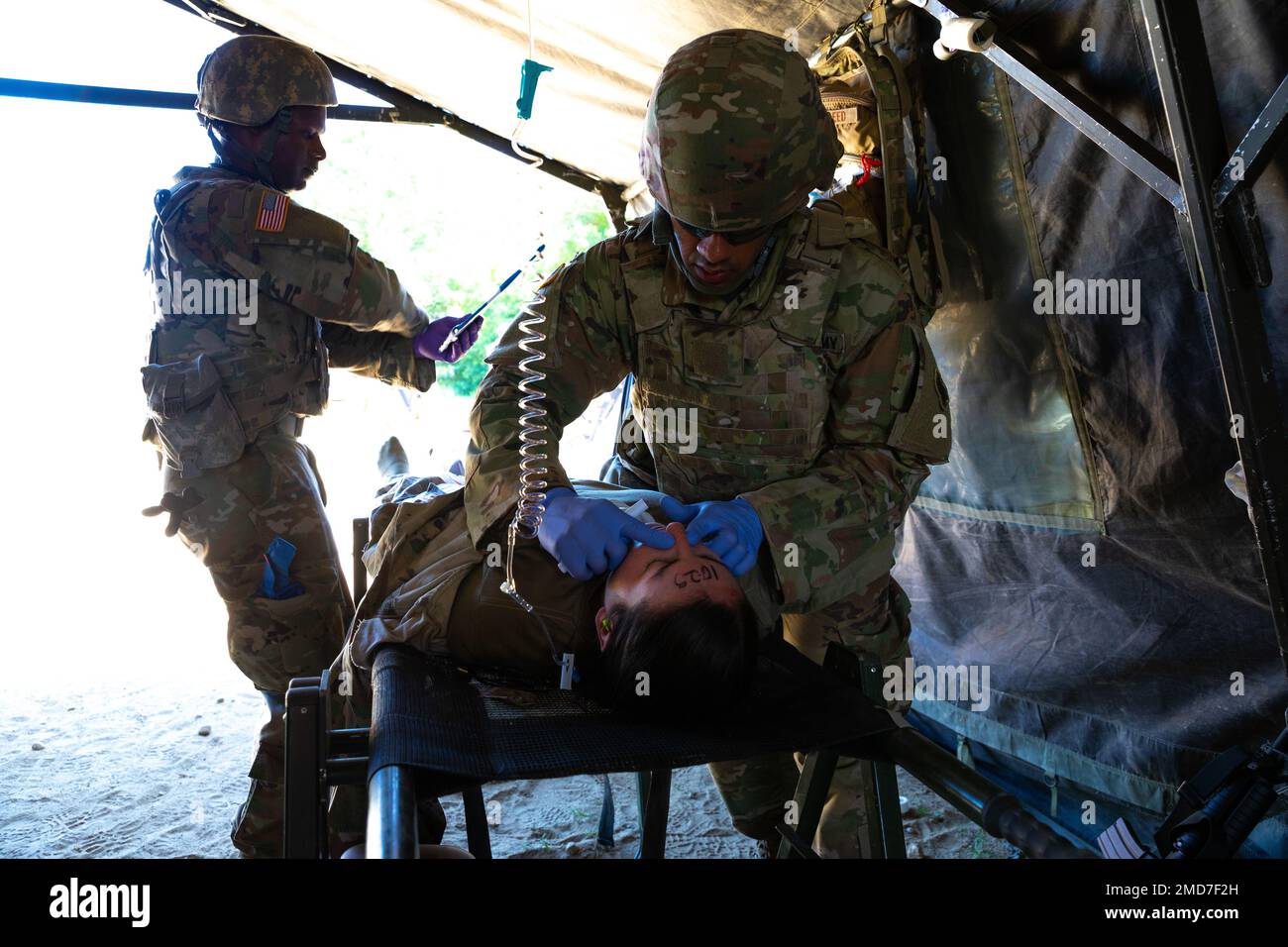 A U.S. Army combat medic in training prepares to insert a ...