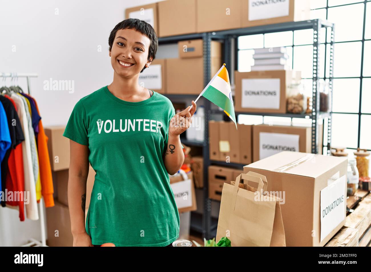Young hispanic woman wearing volunteer uniform holding indian flag at ...
