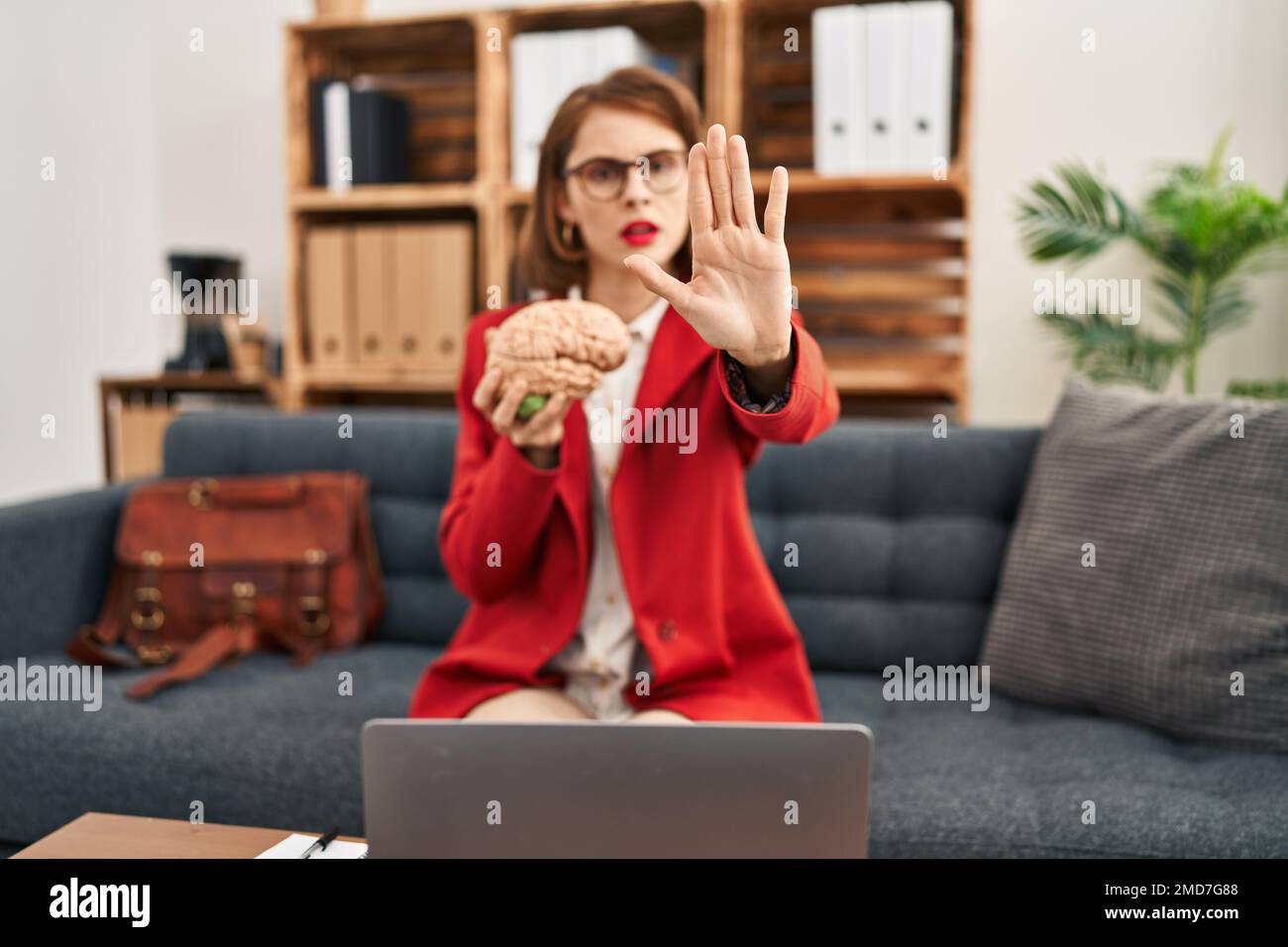 Young brunette woman at consultation office holding brain with open ...