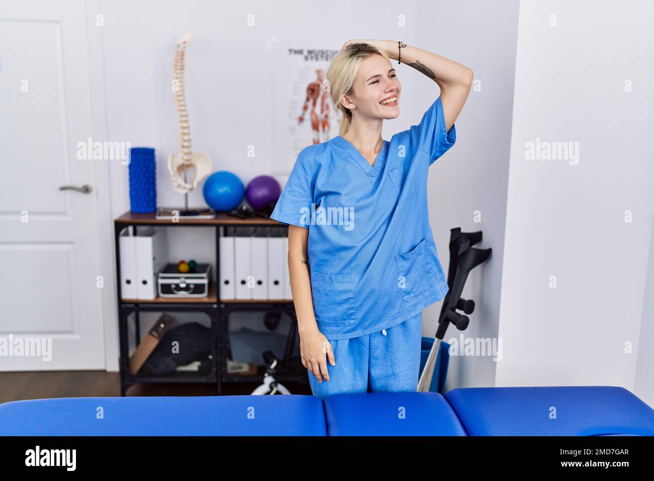 Young physiotherapist woman working at pain recovery clinic smiling ...