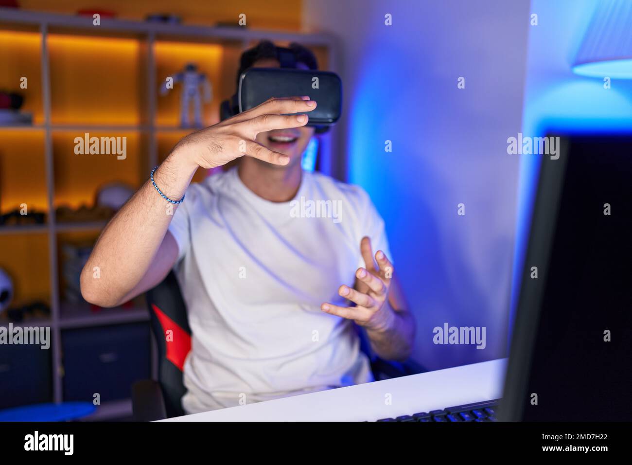 Young hispanic man streamer playing video game using virtual reality ...