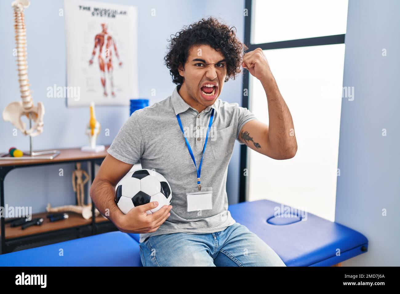 Hispanic man with curly hair working as football physiotherapist angry ...