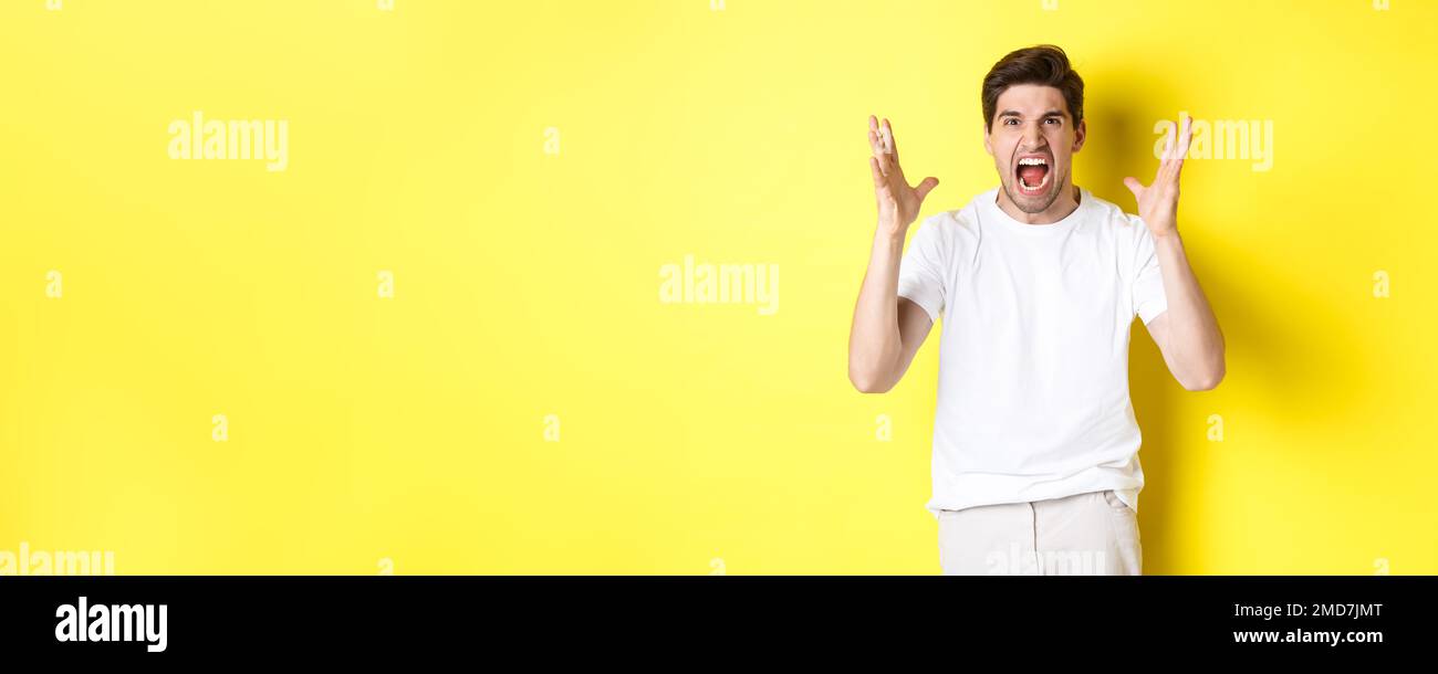 Angry man yelling and shaking hands, grimacing with hatred, standing ...