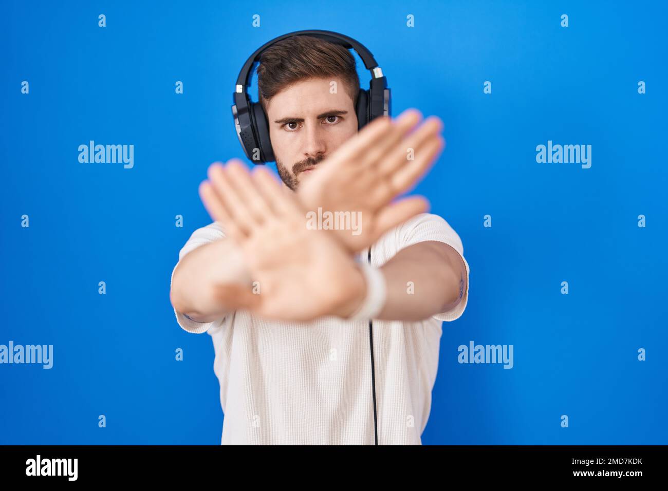 Hispanic man with beard listening to music wearing headphones rejection ...